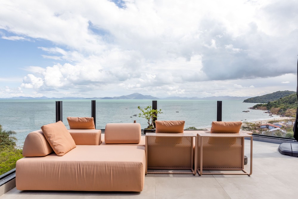 Casa de praia de 379 m² com materiais naturais e móveis planejados