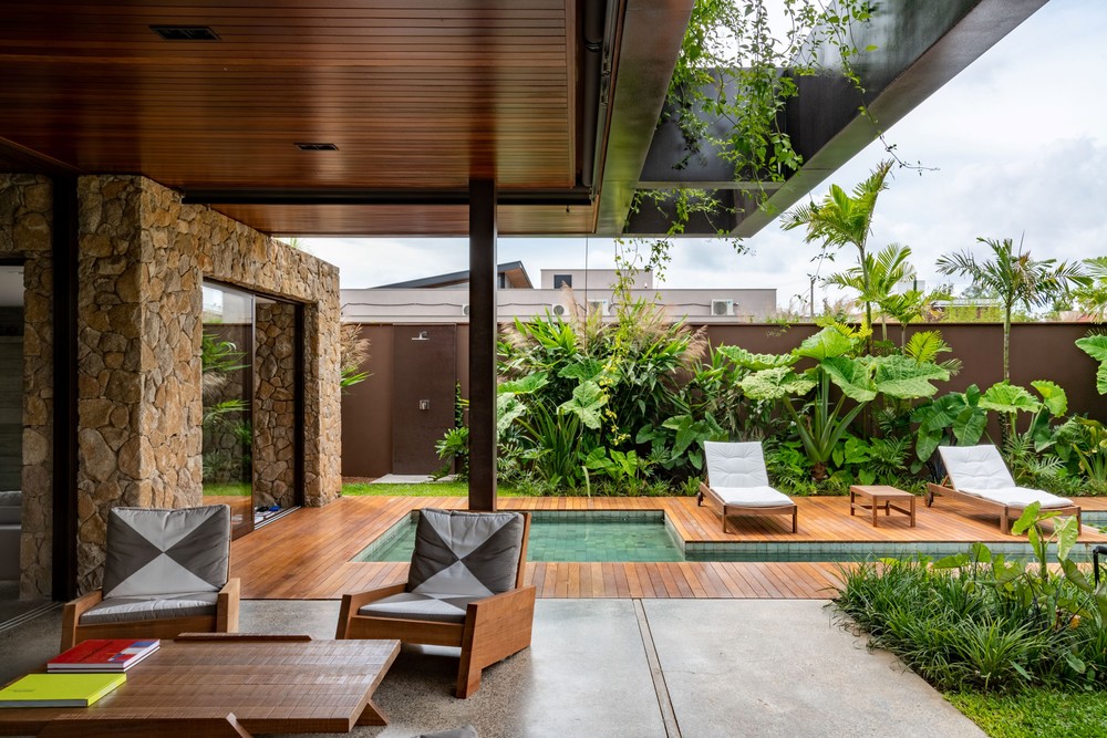 Com pedra e madeira, casa de campo tem área externa e jardim dos sonhos