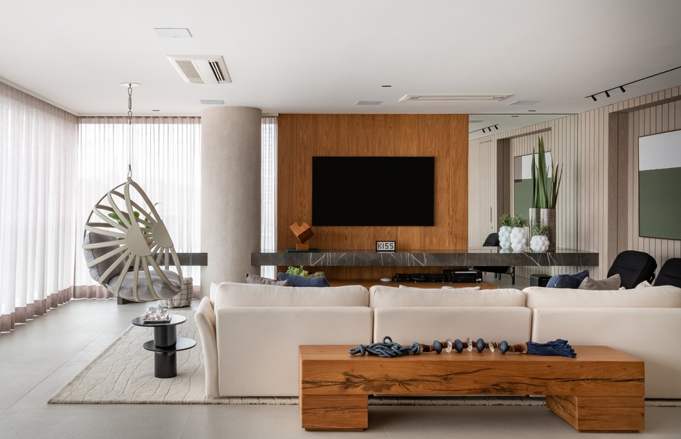 Sala de estar com adega e balanço define apartamento de 186 m²