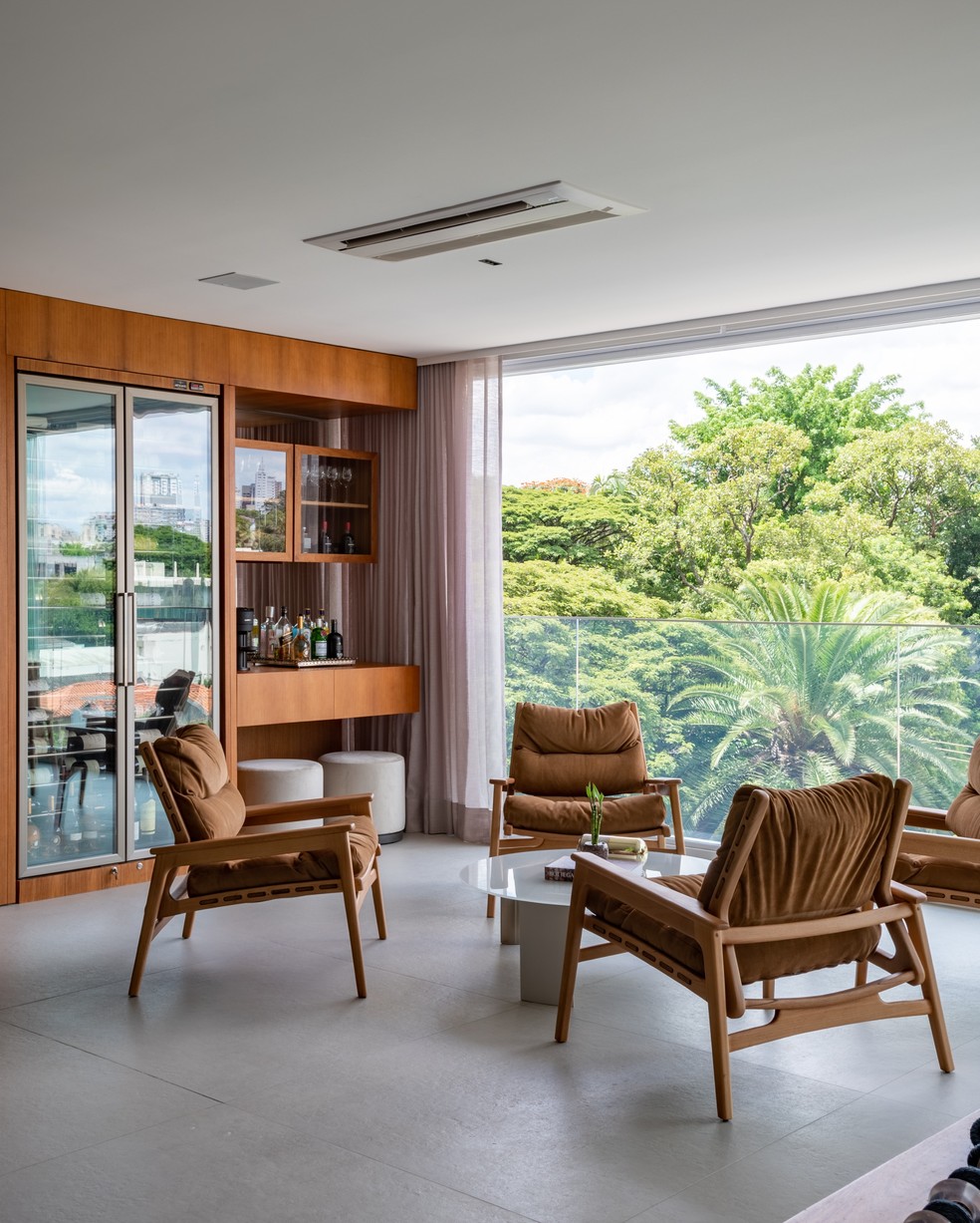 Sala de estar com adega e balanço define apartamento de 186 m²